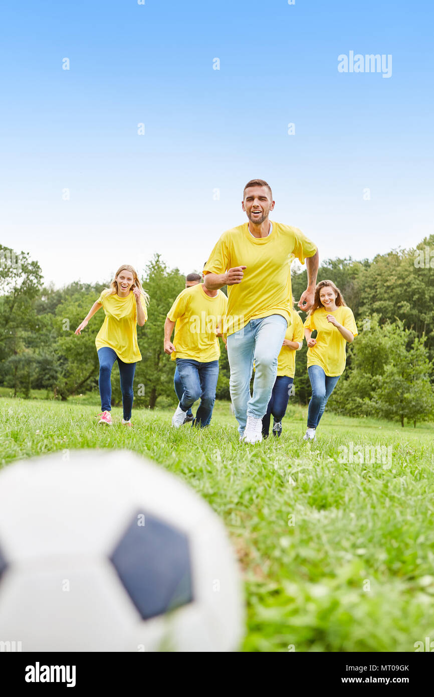 Young people as a team play football in a competition in nature Stock ...
