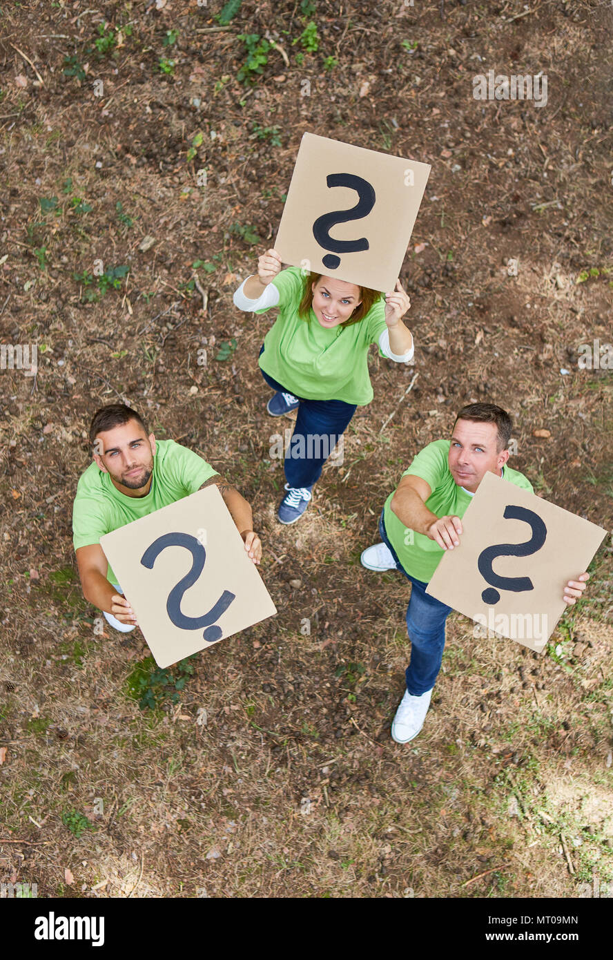 Creative team holds up question marks in a brainstorming workshop Stock ...
