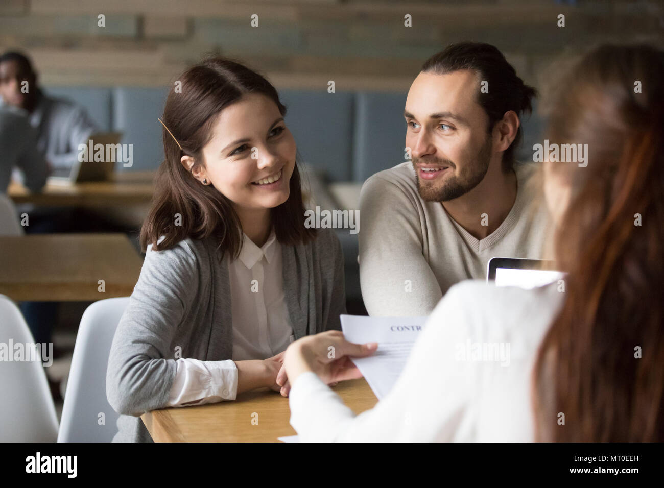 Happy millennial couple planning to sign mortgage contract at me Stock ...