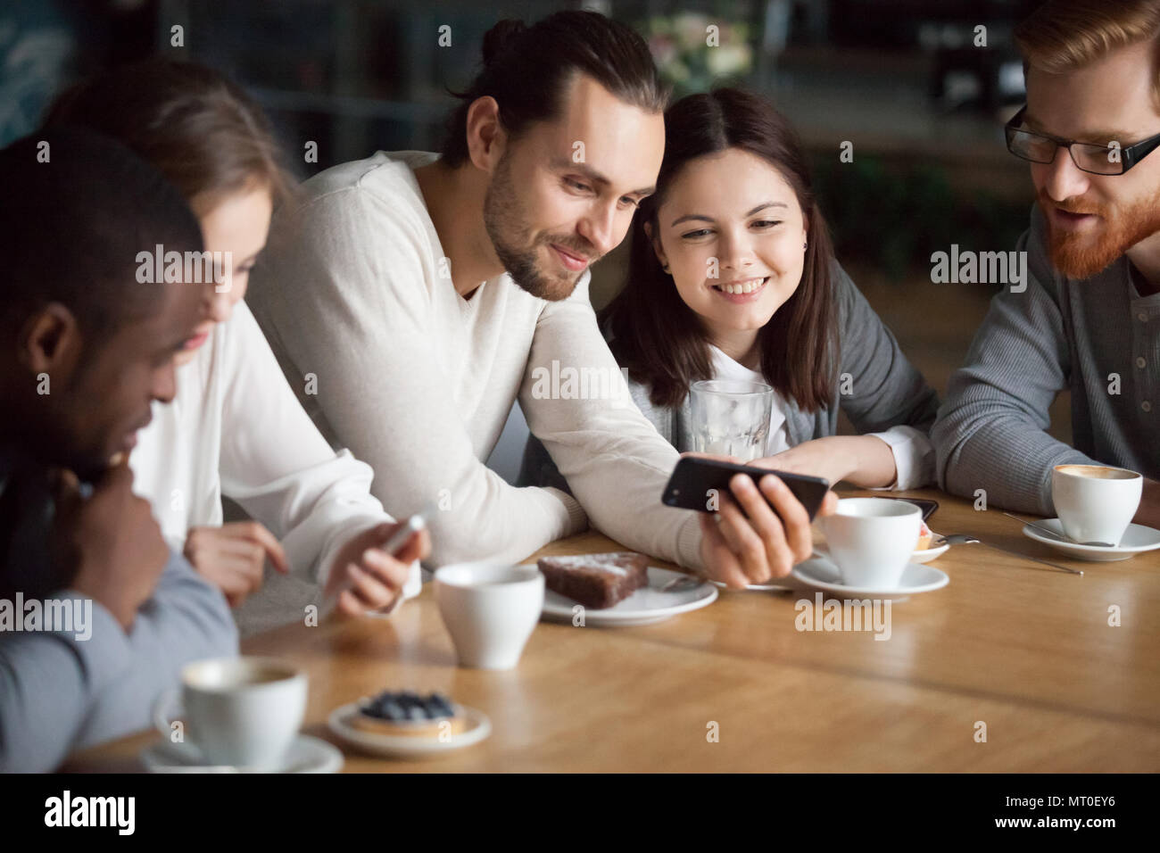 Happy friends using smartphones in hi-res stock photography and images ...