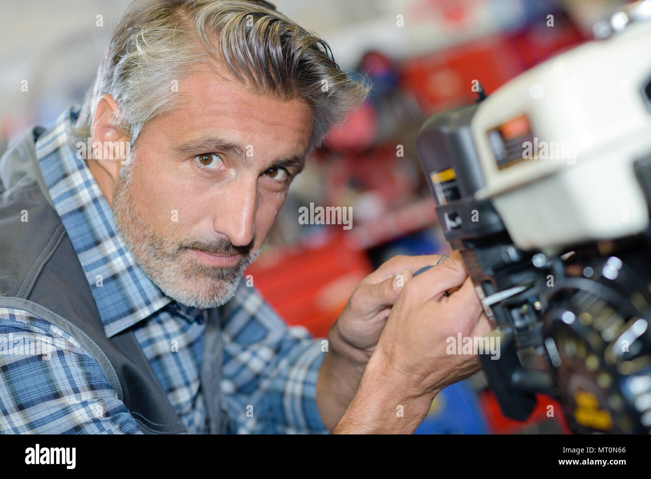 closeup of mechanic working on petrol engine Stock Photo - Alamy