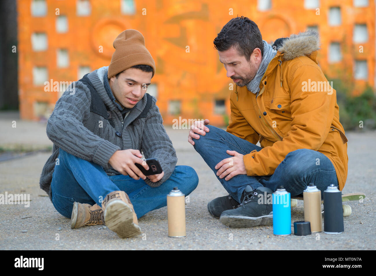 two young men doing street art graffiti Stock Photo - Alamy