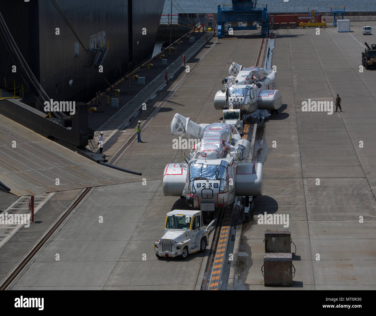 Tug military mid-range tow tractors pull two MH-53E helicopters before ...