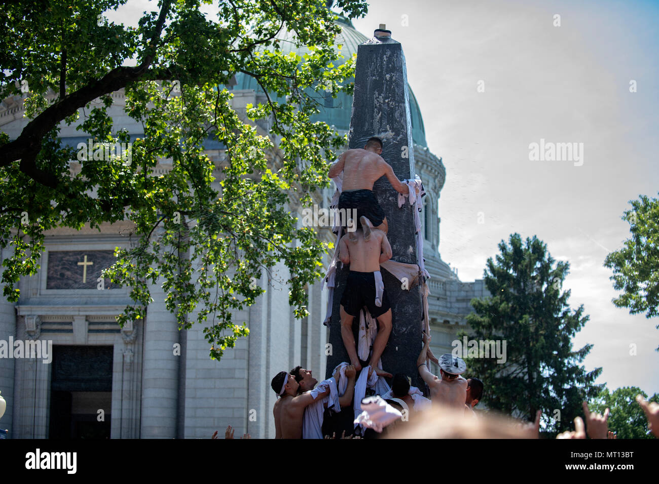 U.S Naval Academy plebes form a human pyramid around the greased ...