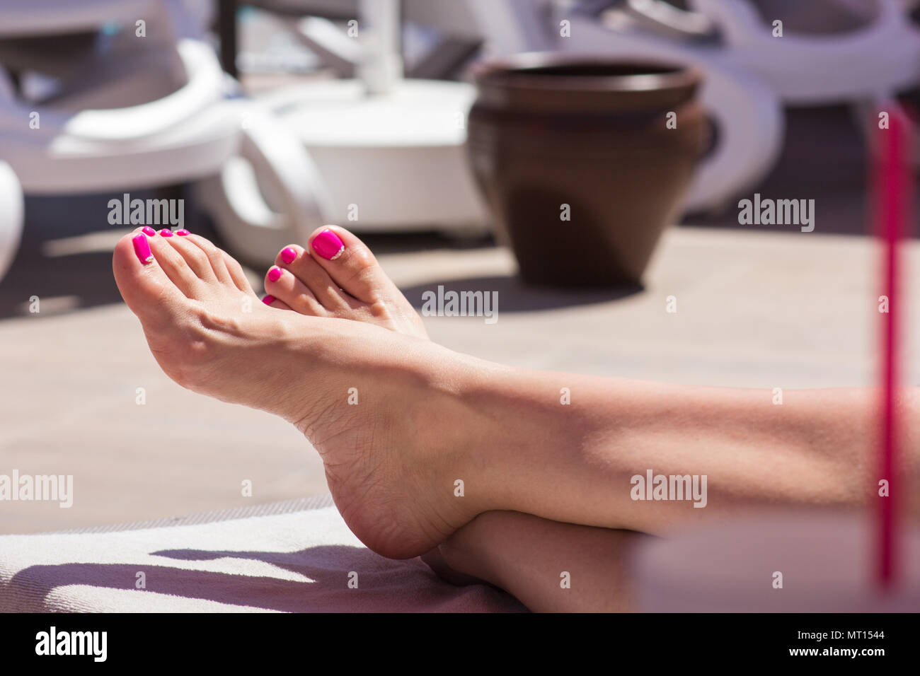 Beautiful female legs sunbathing on a chaise longue Stock Photo - Alamy
