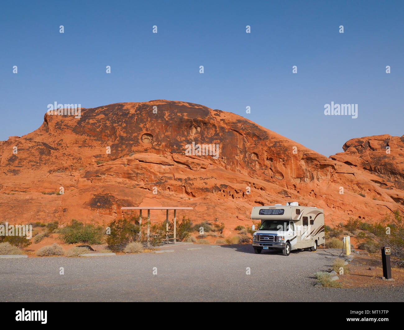 An RV motor home is parked at a campsite in the desert of Valley of ...