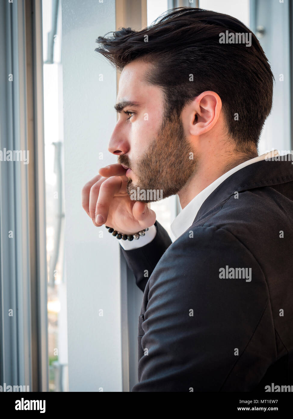 Handsome serious businessman standing inside modern building next to ...