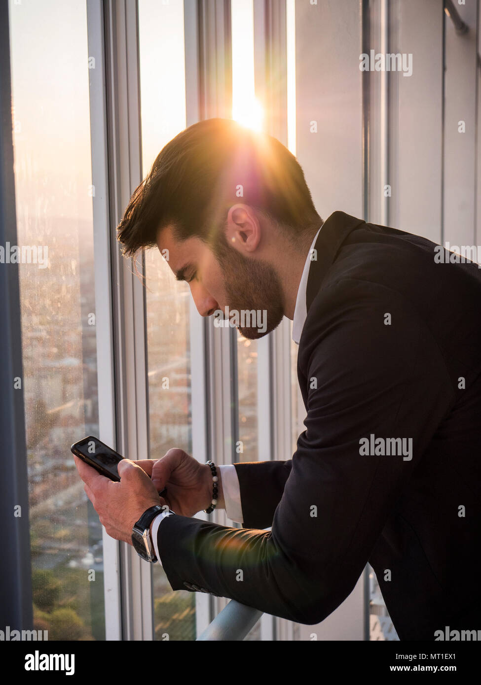 Handsome serious businessman standing inside modern building using ...