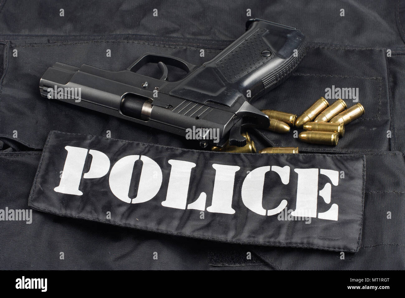 police handgun on black uniform background Stock Photo - Alamy