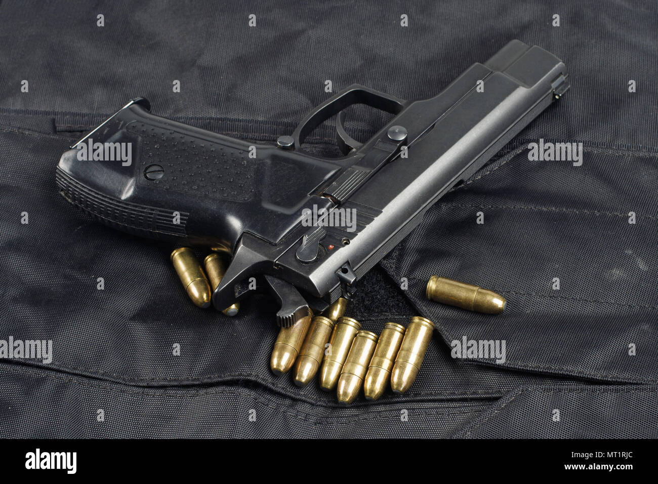 police handgun on black uniform background Stock Photo - Alamy