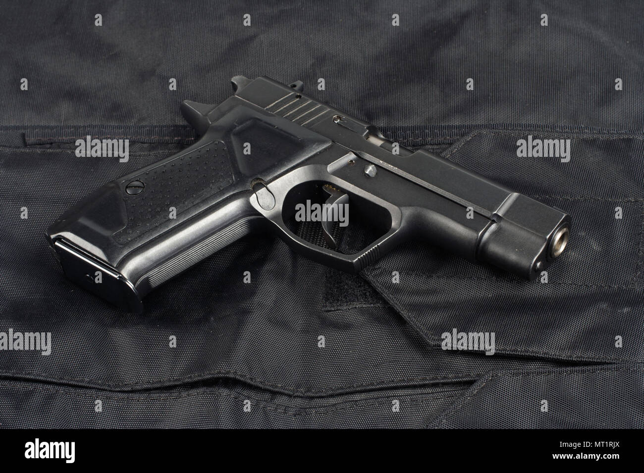 police handgun on black uniform background Stock Photo - Alamy