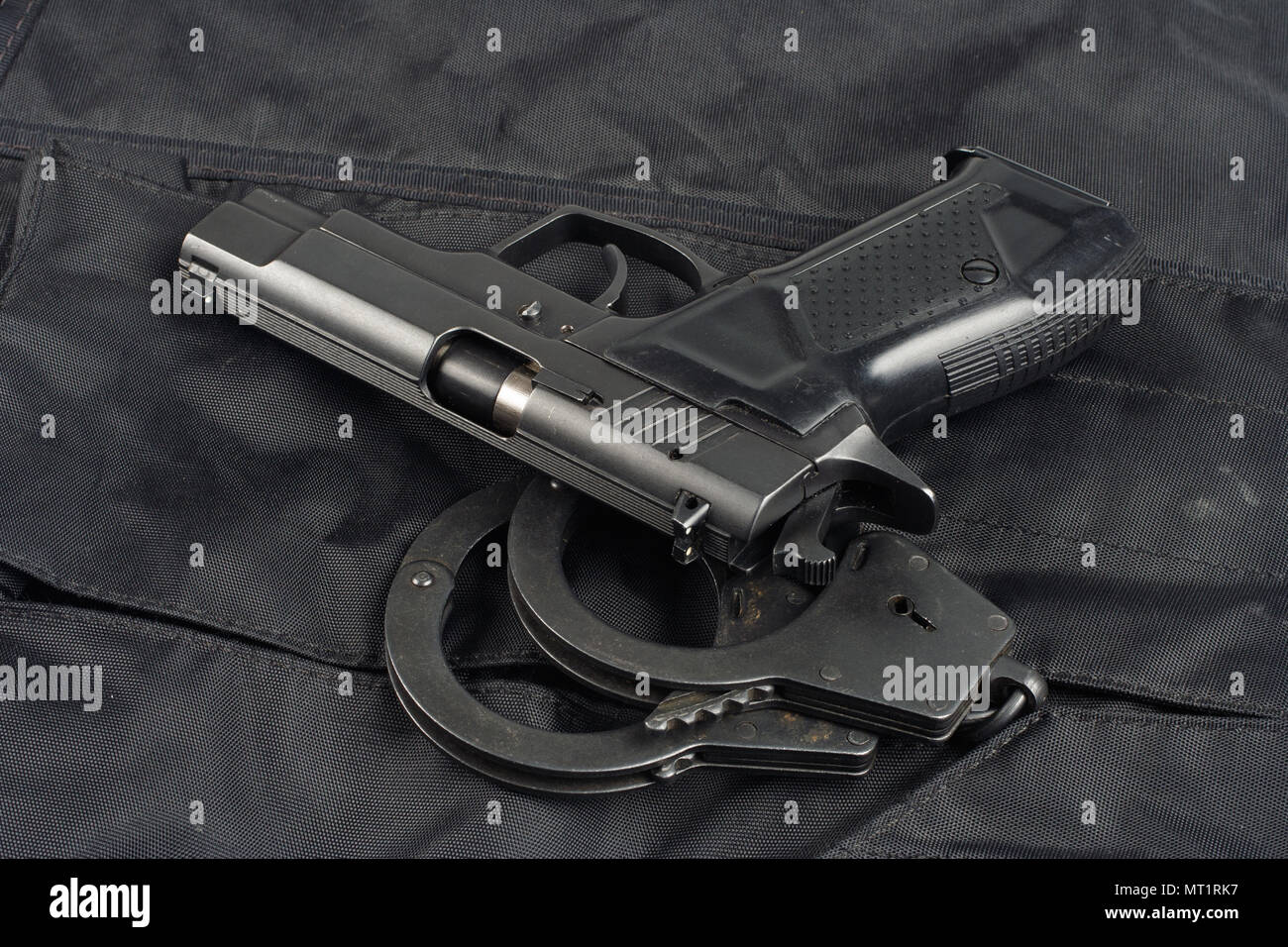 police handgun on black uniform background Stock Photo - Alamy