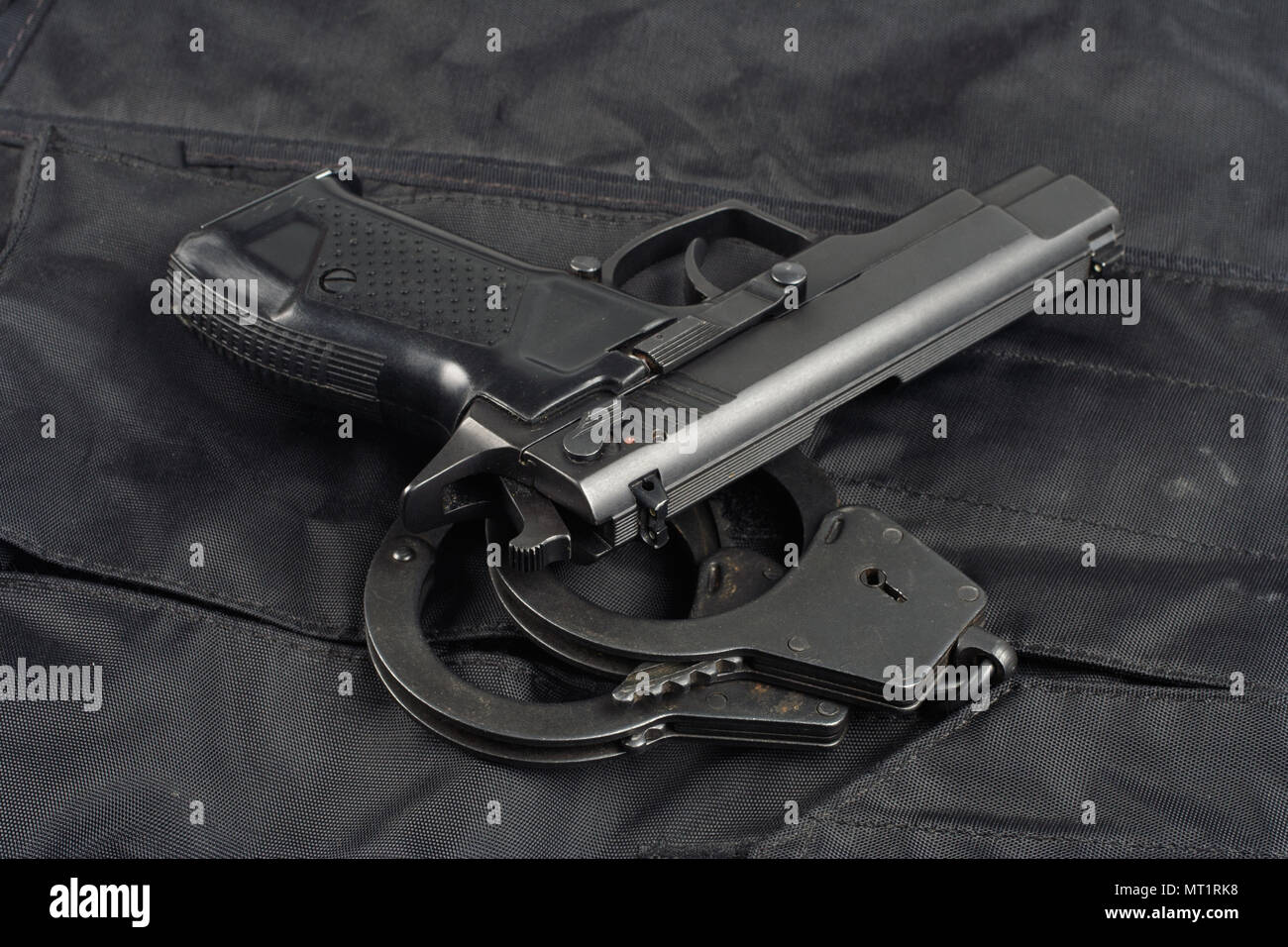 police handgun on black uniform background Stock Photo - Alamy