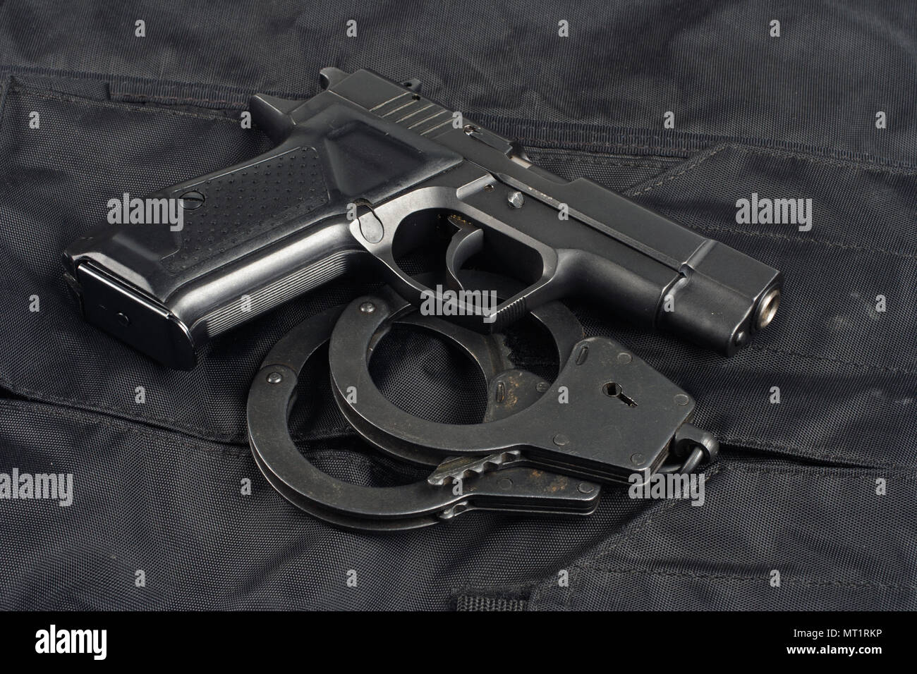 police handgun on black uniform background Stock Photo - Alamy