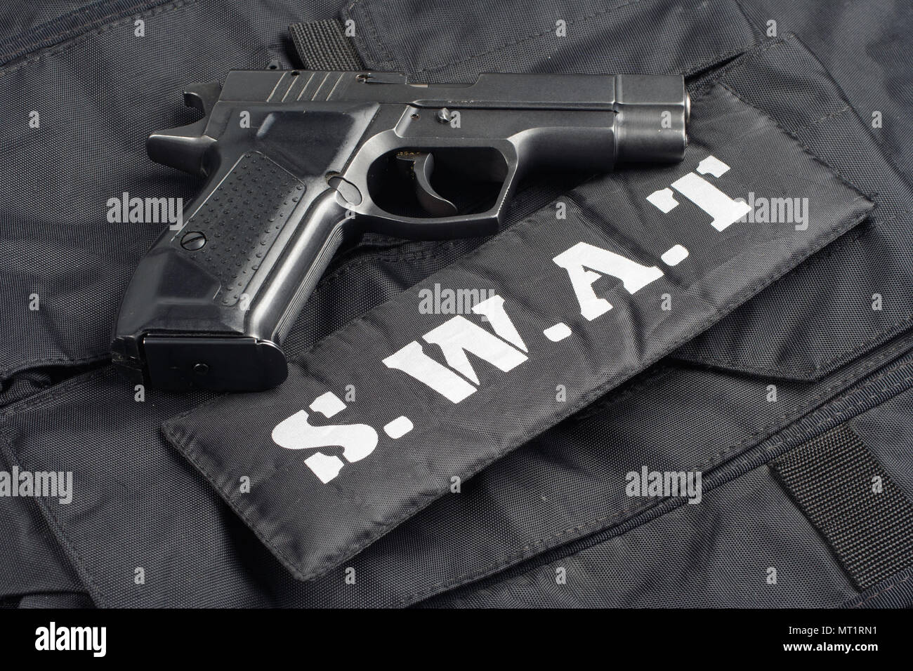 SWAT handgun on black uniform background Stock Photo - Alamy