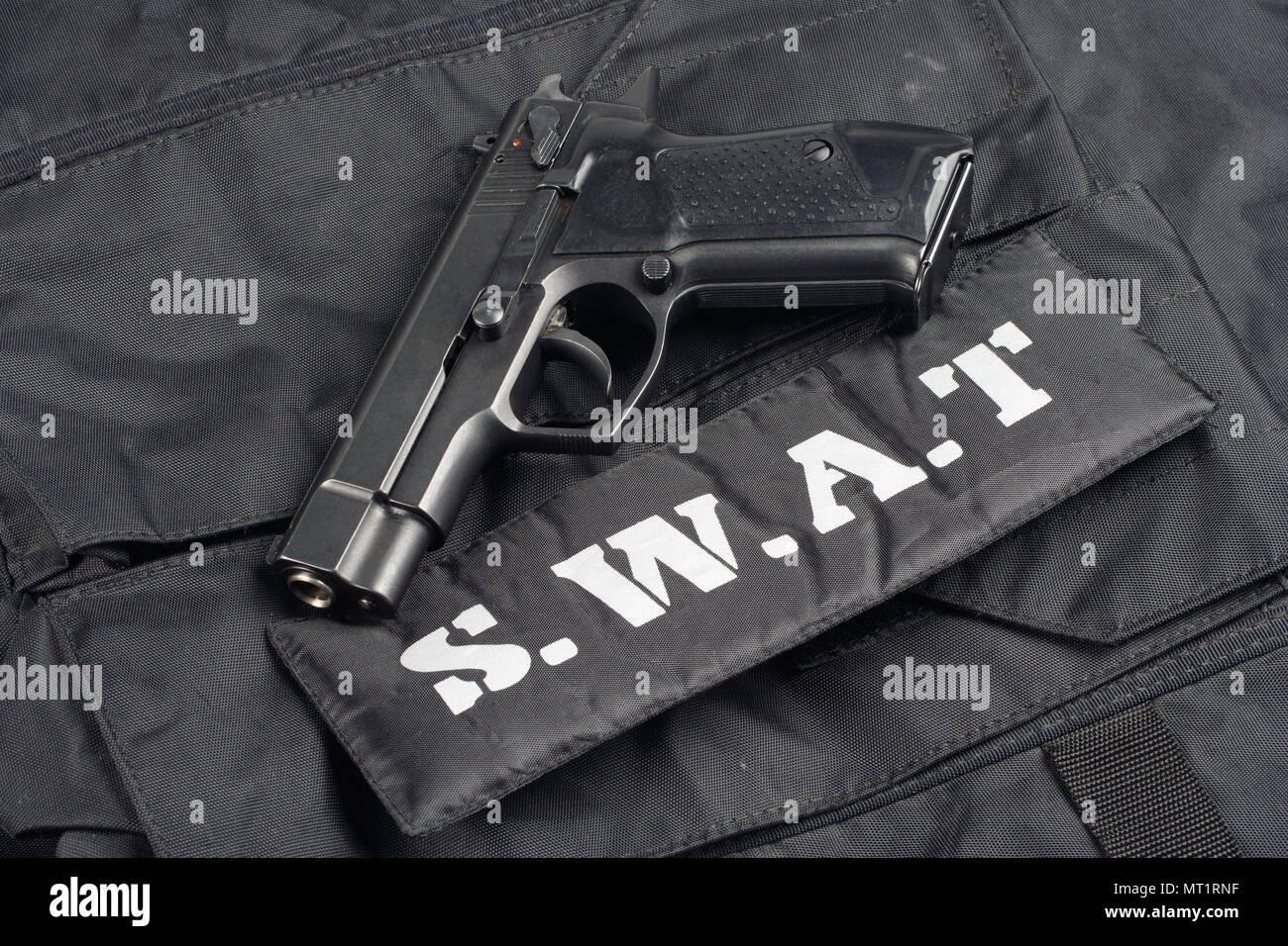 SWAT handgun on black uniform background Stock Photo - Alamy