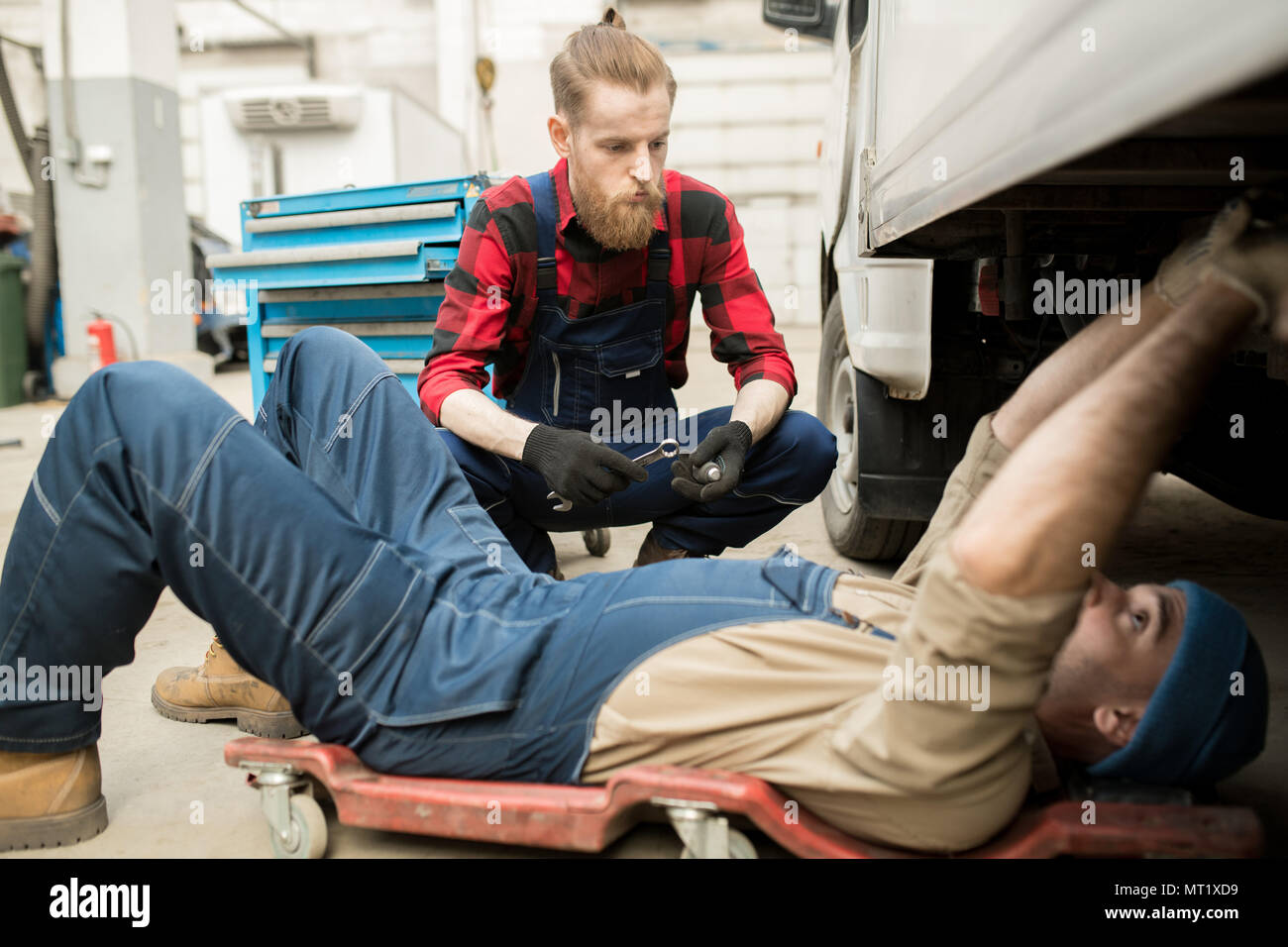 Mechanics Repairing Vehicle In Garage Stock Photo - Alamy