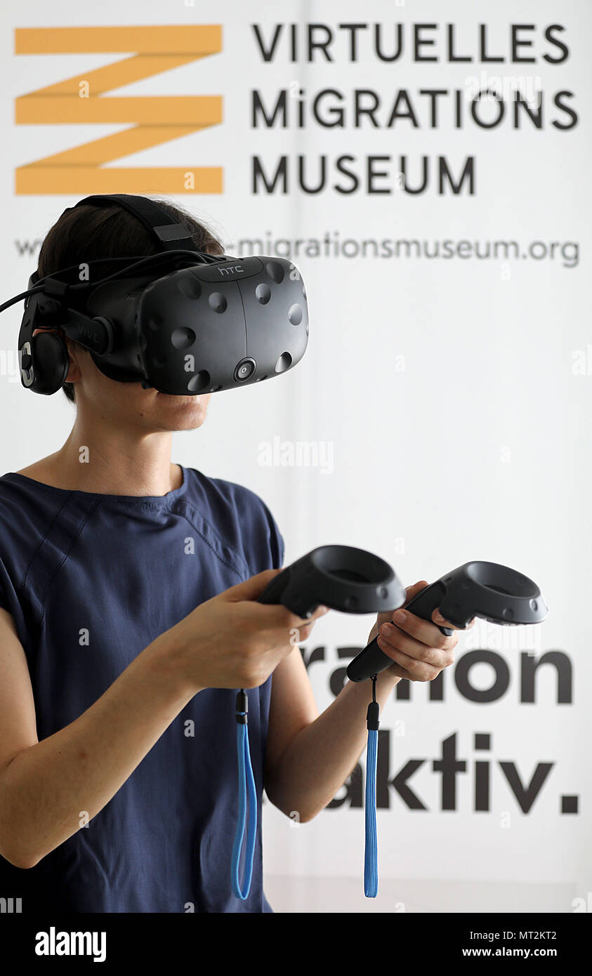 28 May 2018, Germany, Cologne: A staff member wearing VR goggles at the ...