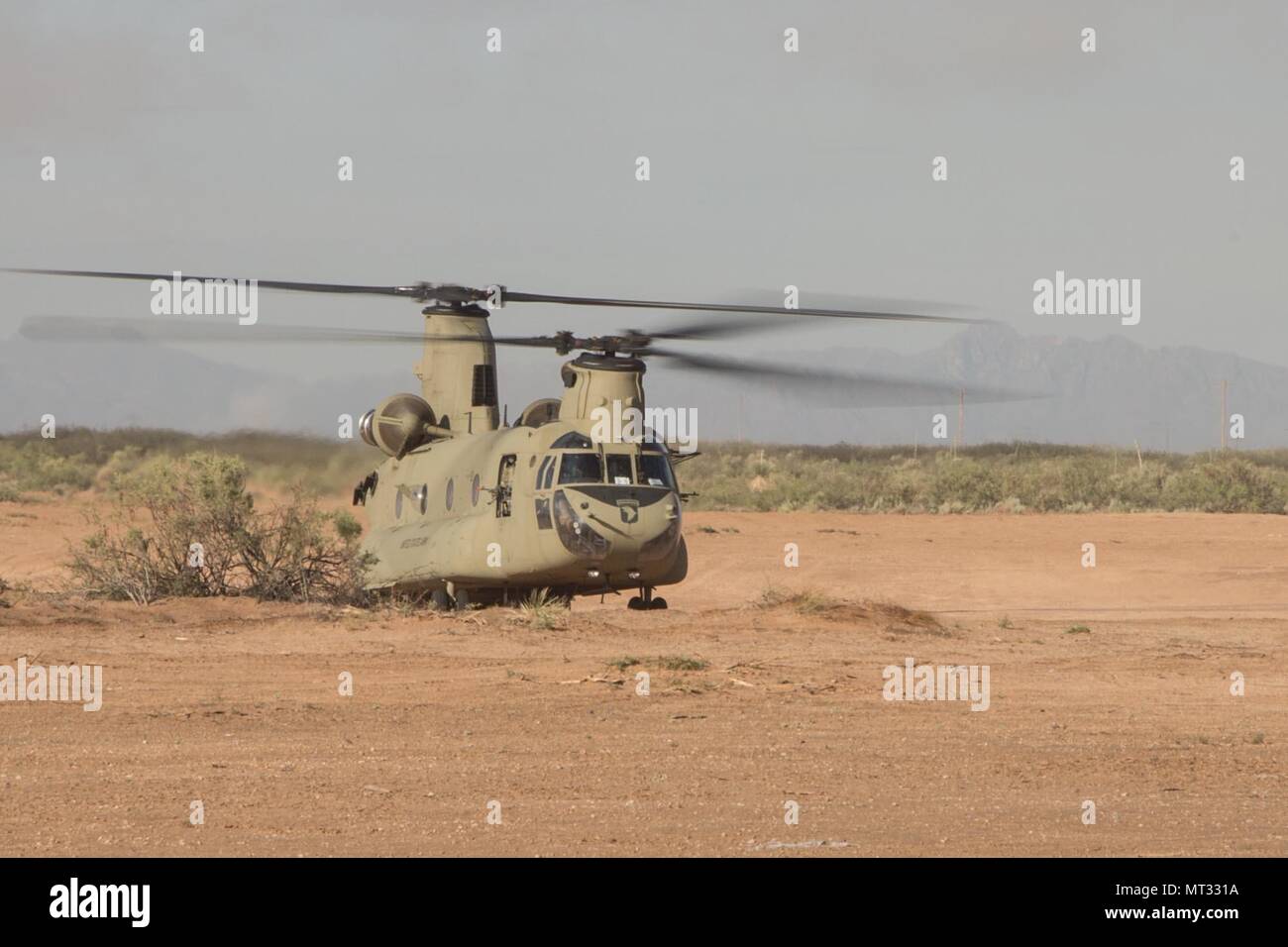 CH-47 Chinook prepares to load Soldiers and transport a HUMVEE during a sling load operation ...