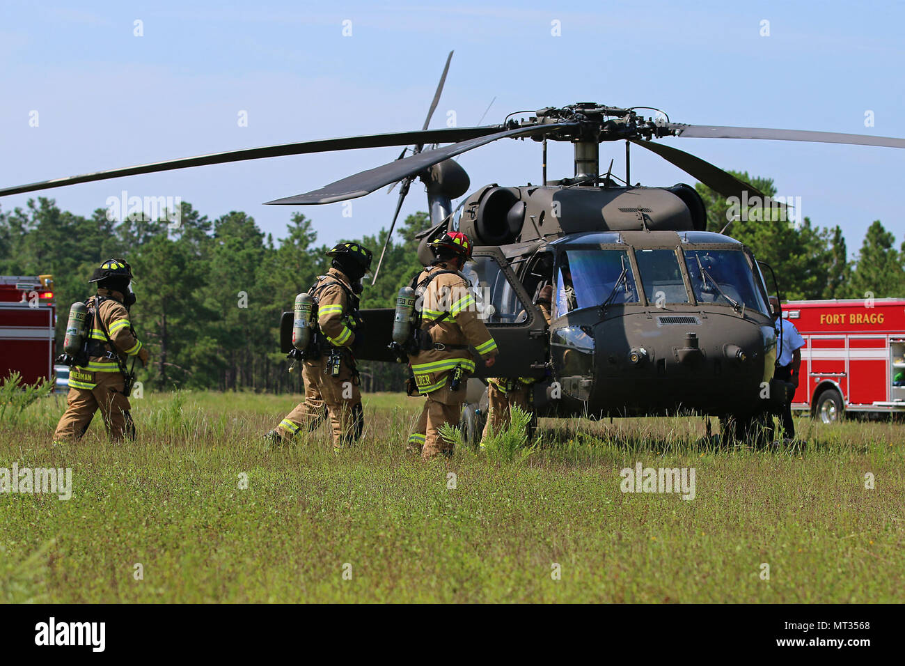 Firefighters from Fort Bragg Fire and Emergency Services move toward a ...