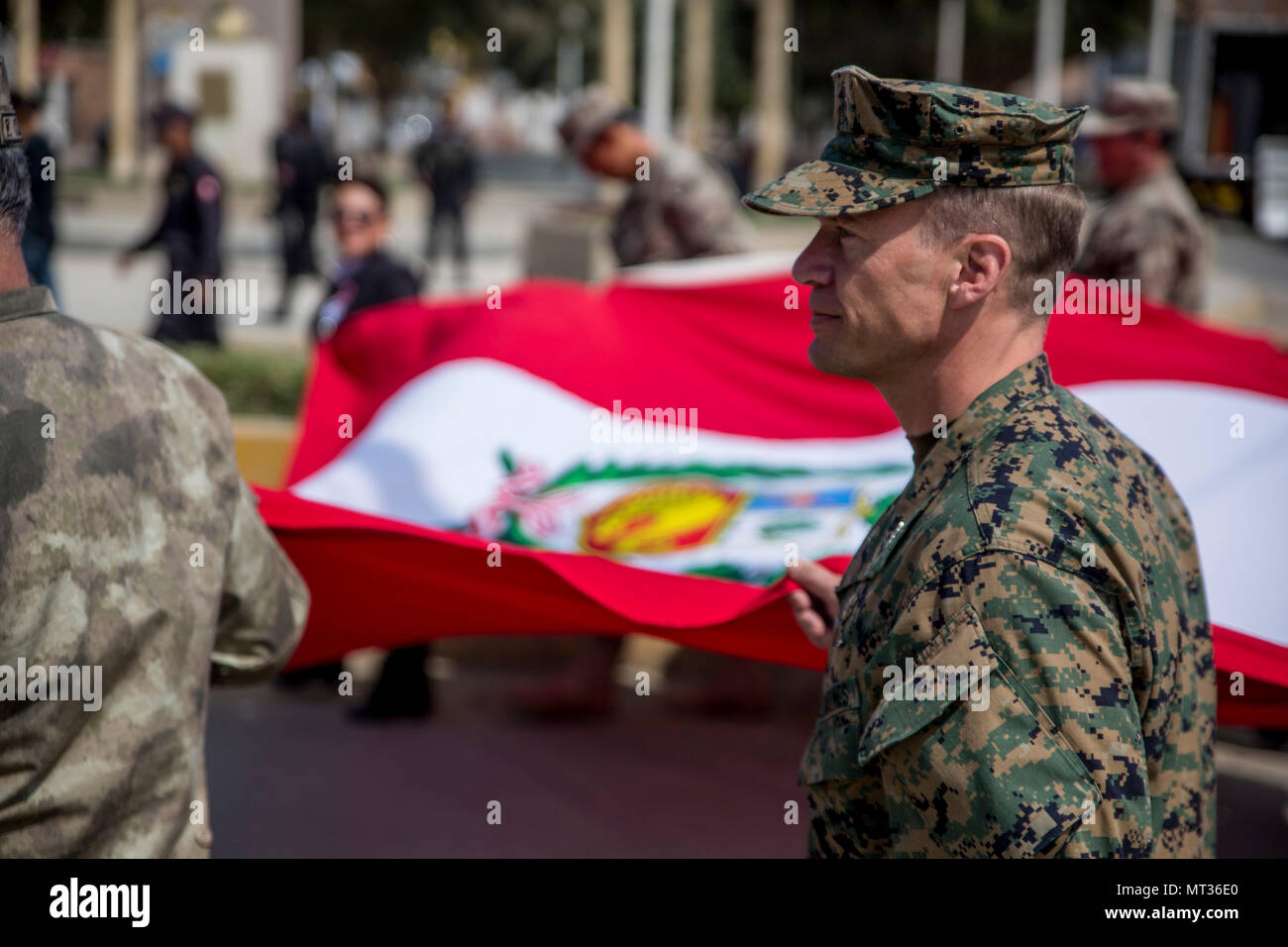 U.S. Marine Col. Paul Konopka holds on to the Peruvian national flag ...