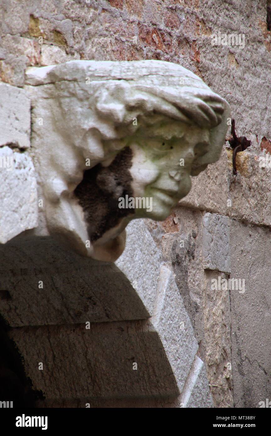 Bust attached to brick-built footbridge over Venetian canal Stock Photo ...