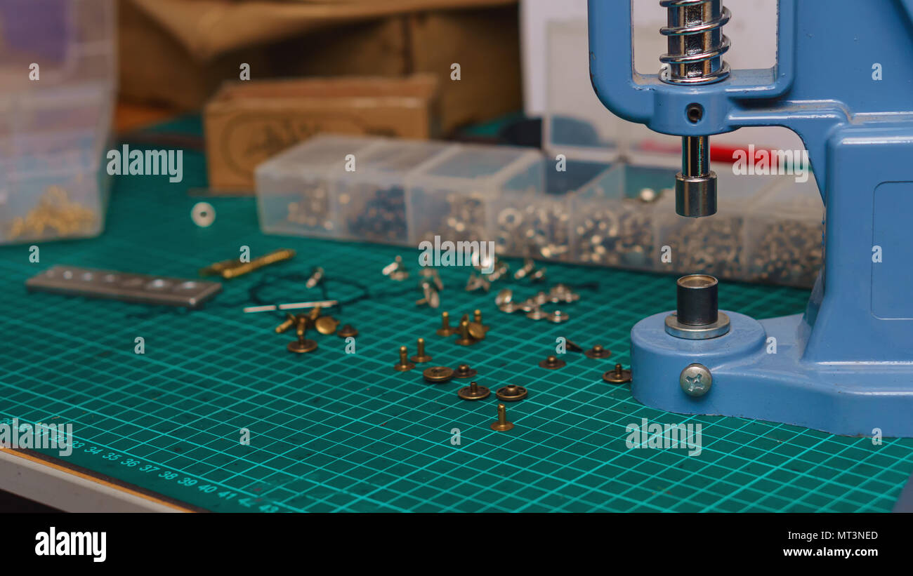 Tools of the tanner. Riveter, awl rivets and fasteners are on the table ...