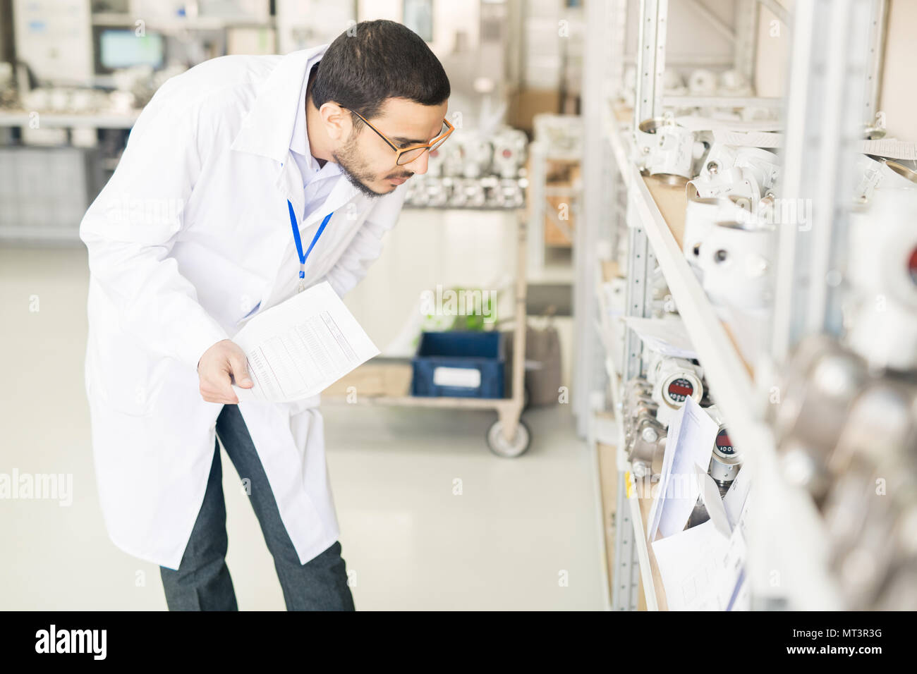 Busy Arabian engineer examining devices in warehouse Stock Photo - Alamy