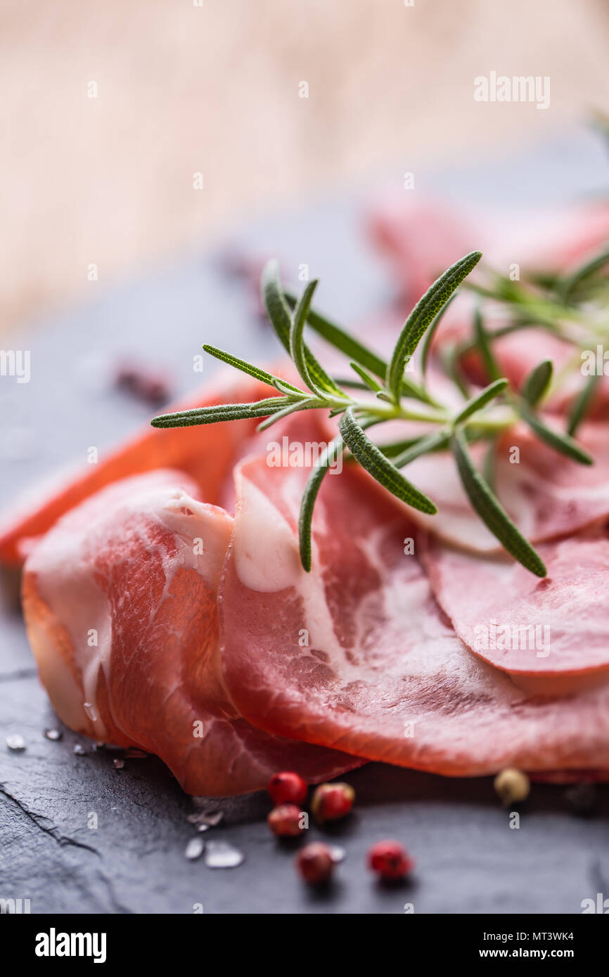 Coppa di Parma ham on slate board with rosemary salt and pepper Stock ...