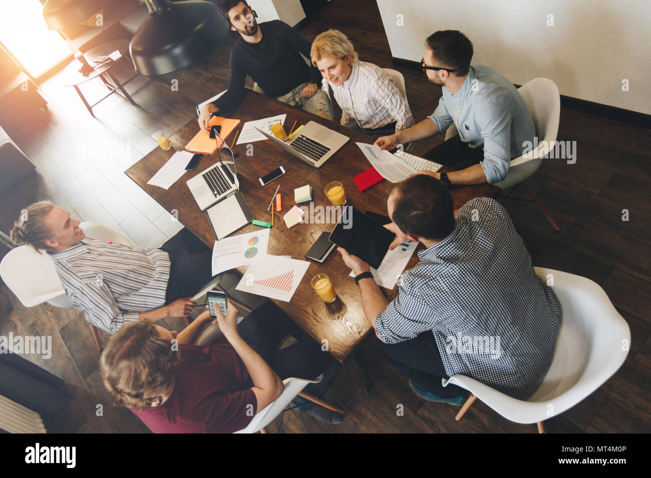 Business man and woman sitting around table at office and working with ...