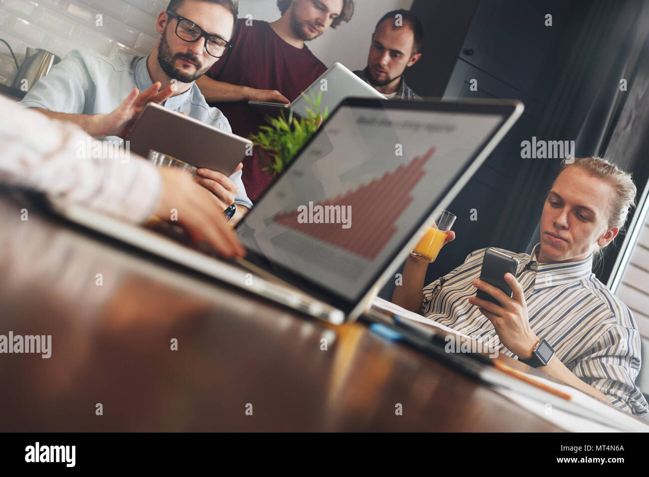 Business teamwork on home group of modern hipsters seated around wooden ...