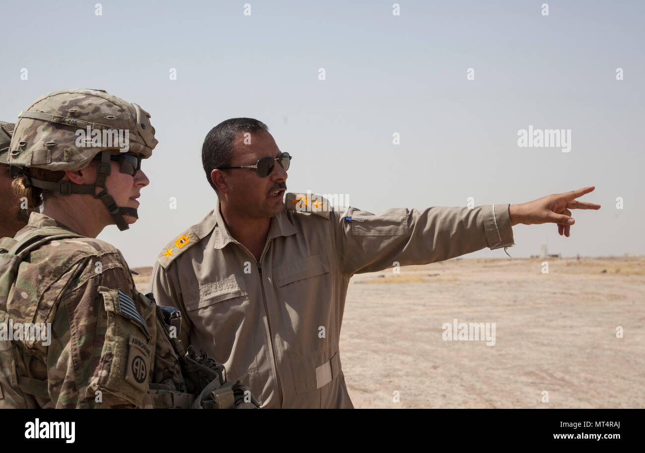 An Iraqi security force member speaks with U.S. Army Lt. Col. Elizabeth ...