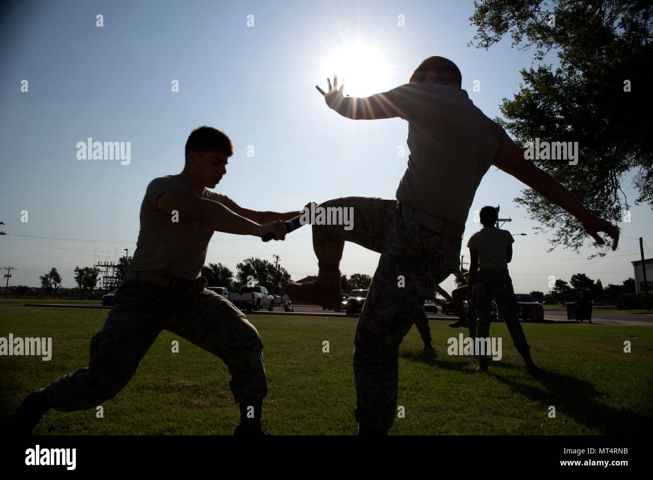 An Airman training for augmentee duty blocks a kick with a baton from a ...
