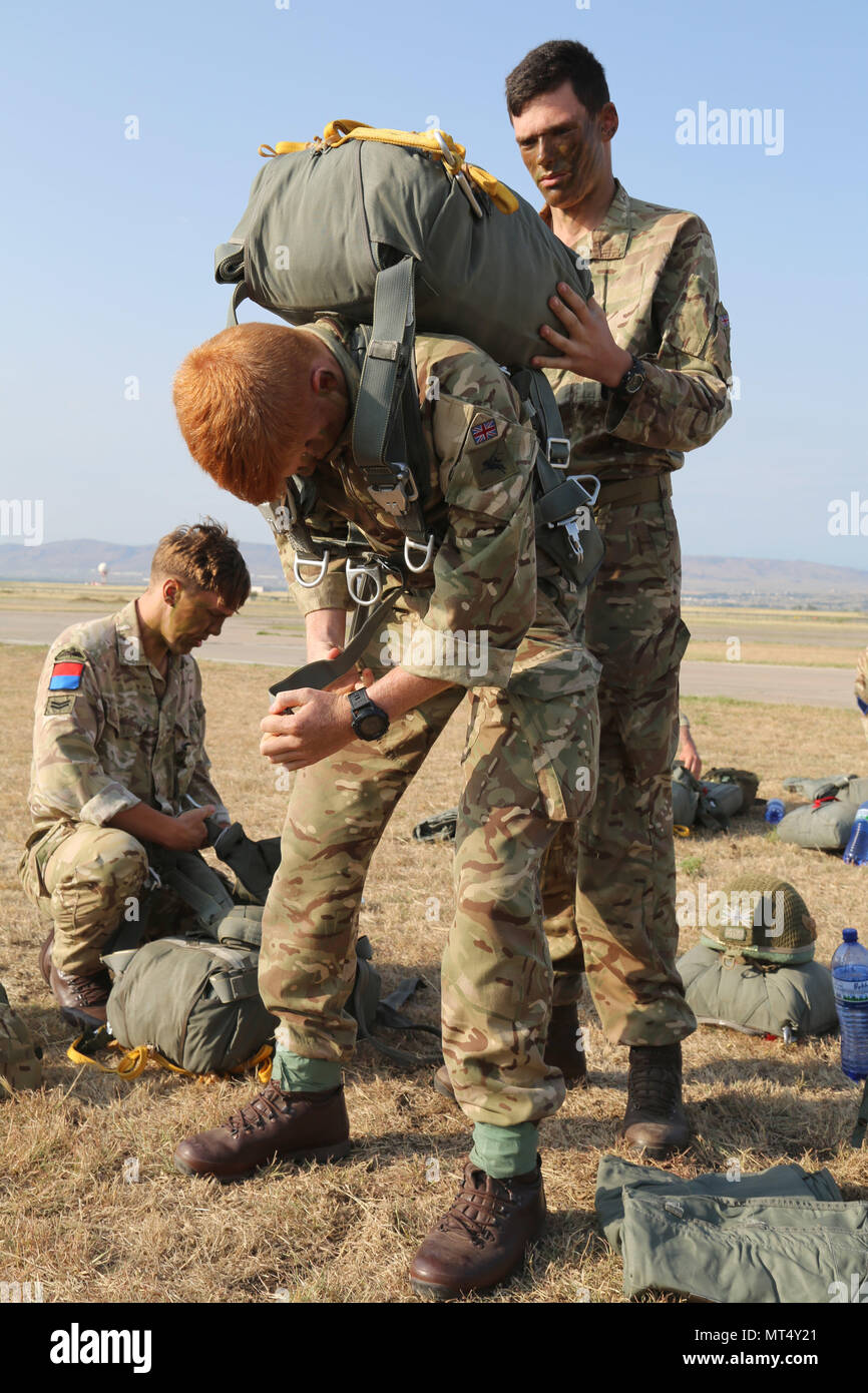 British soldiers, 2nd Parachute Regiment, adjust their main parachute ...