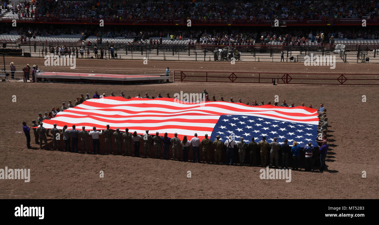 Members of the military and local community present the American flag ...