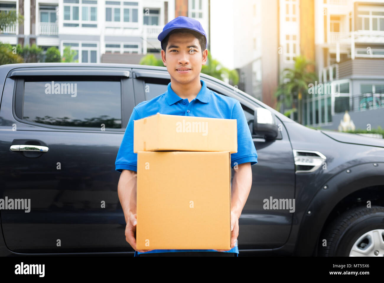 Delivery messenger man with cardboard box outside the warehouse Stock ...