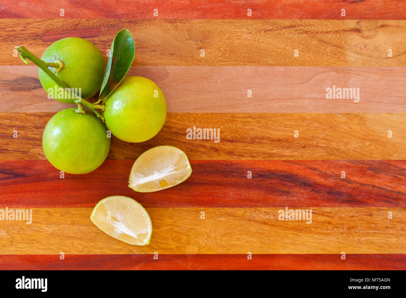 Key lime or Mexican lime on wooden table, one of main ingredient thai ...
