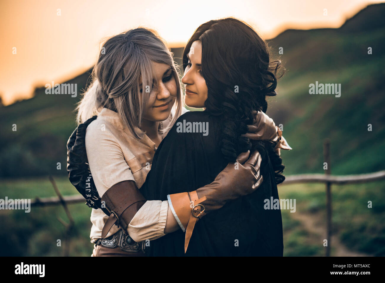 Fantasy cosplay two beautiful girls hug in nature Stock Photo - Alamy