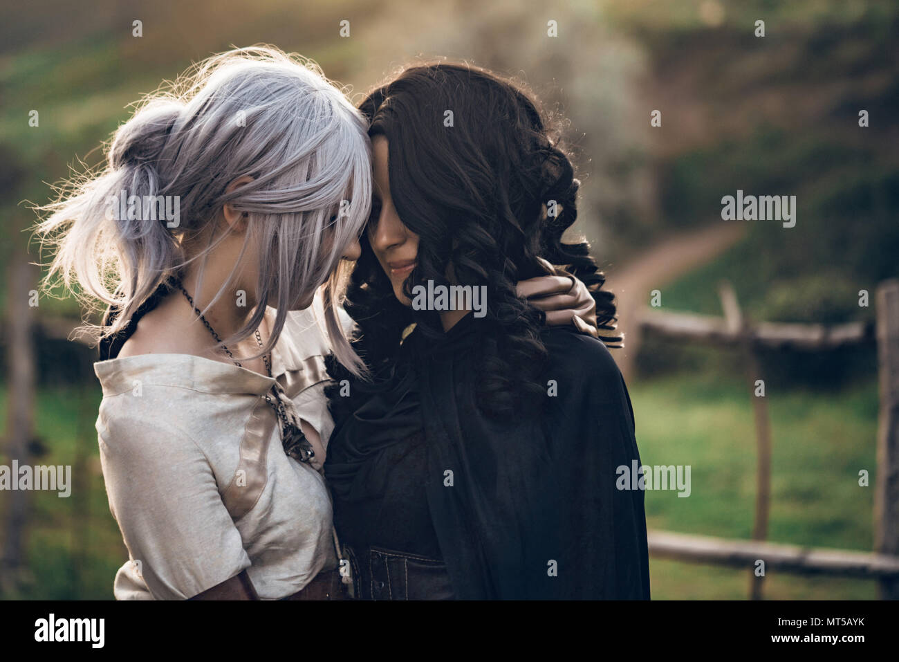Fantasy cosplay two beautiful girls hug in nature Stock Photo - Alamy