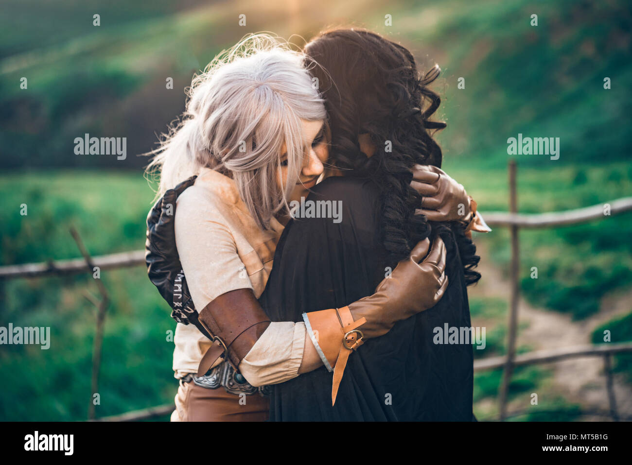 Fantasy cosplay two beautiful girls hug in nature Stock Photo - Alamy