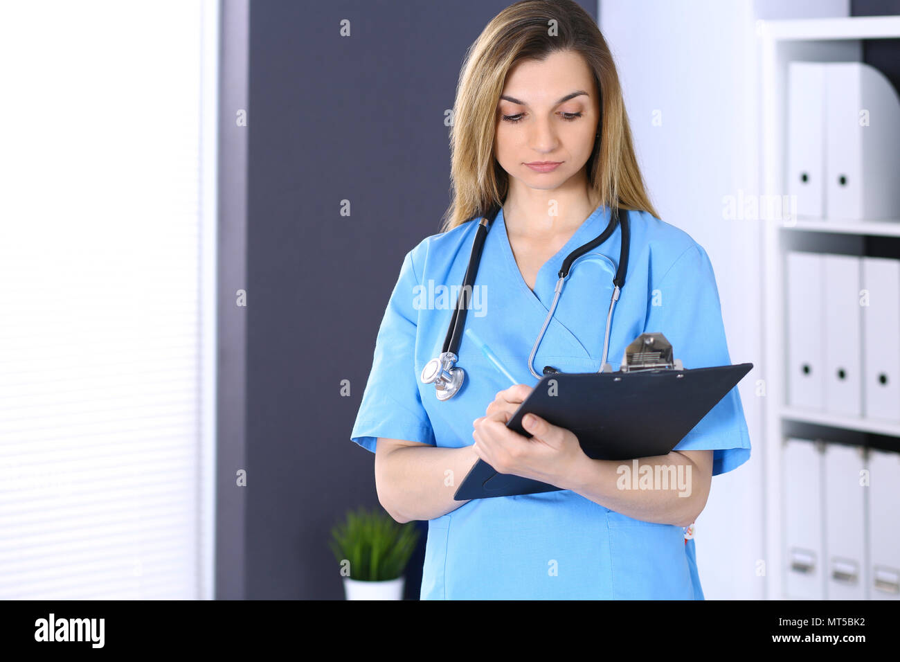 Woman doctor at work in hospital office. Portrait of female physician ...