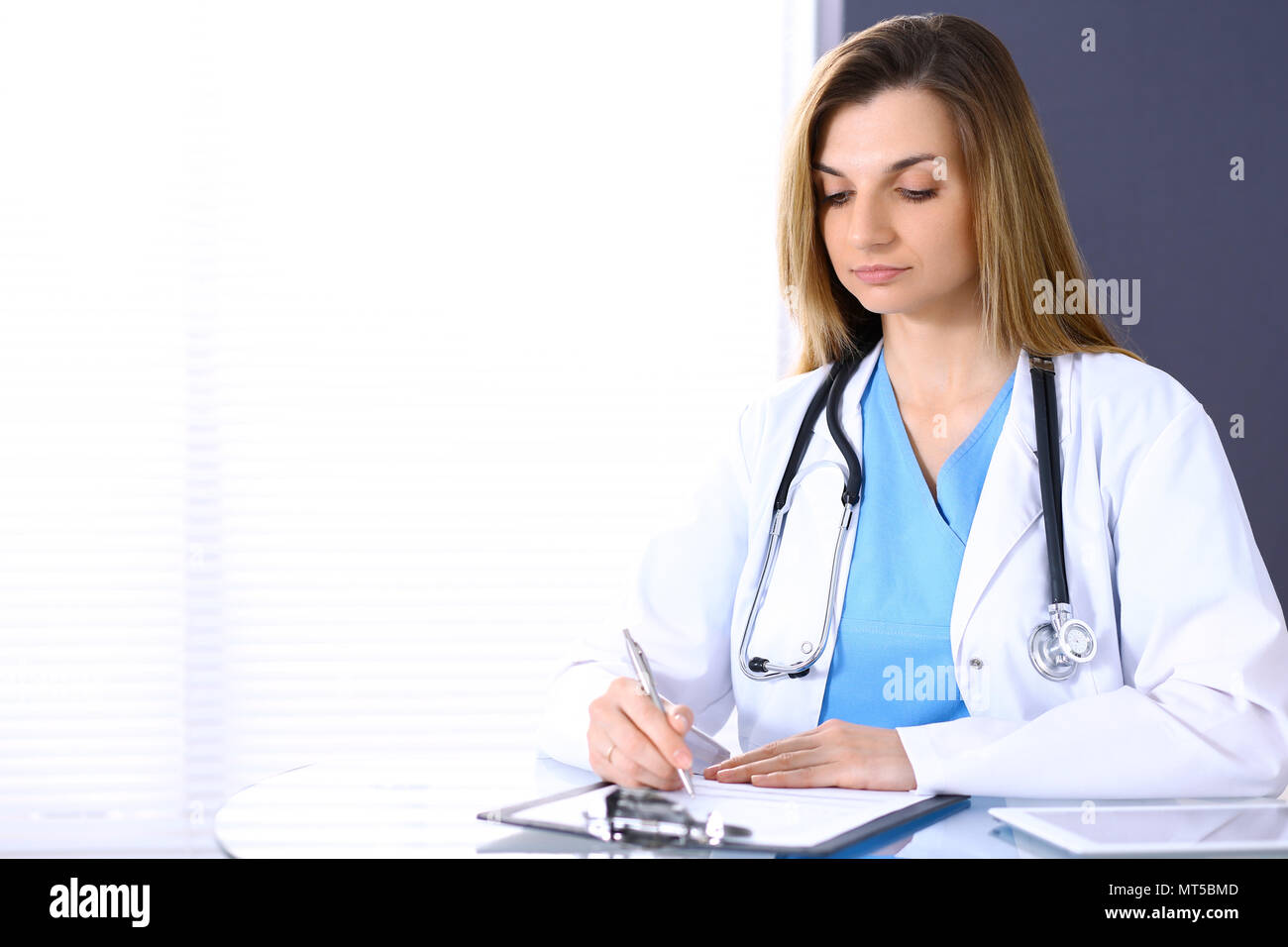 Woman doctor at work in hospital office. Portrait of female physician ...