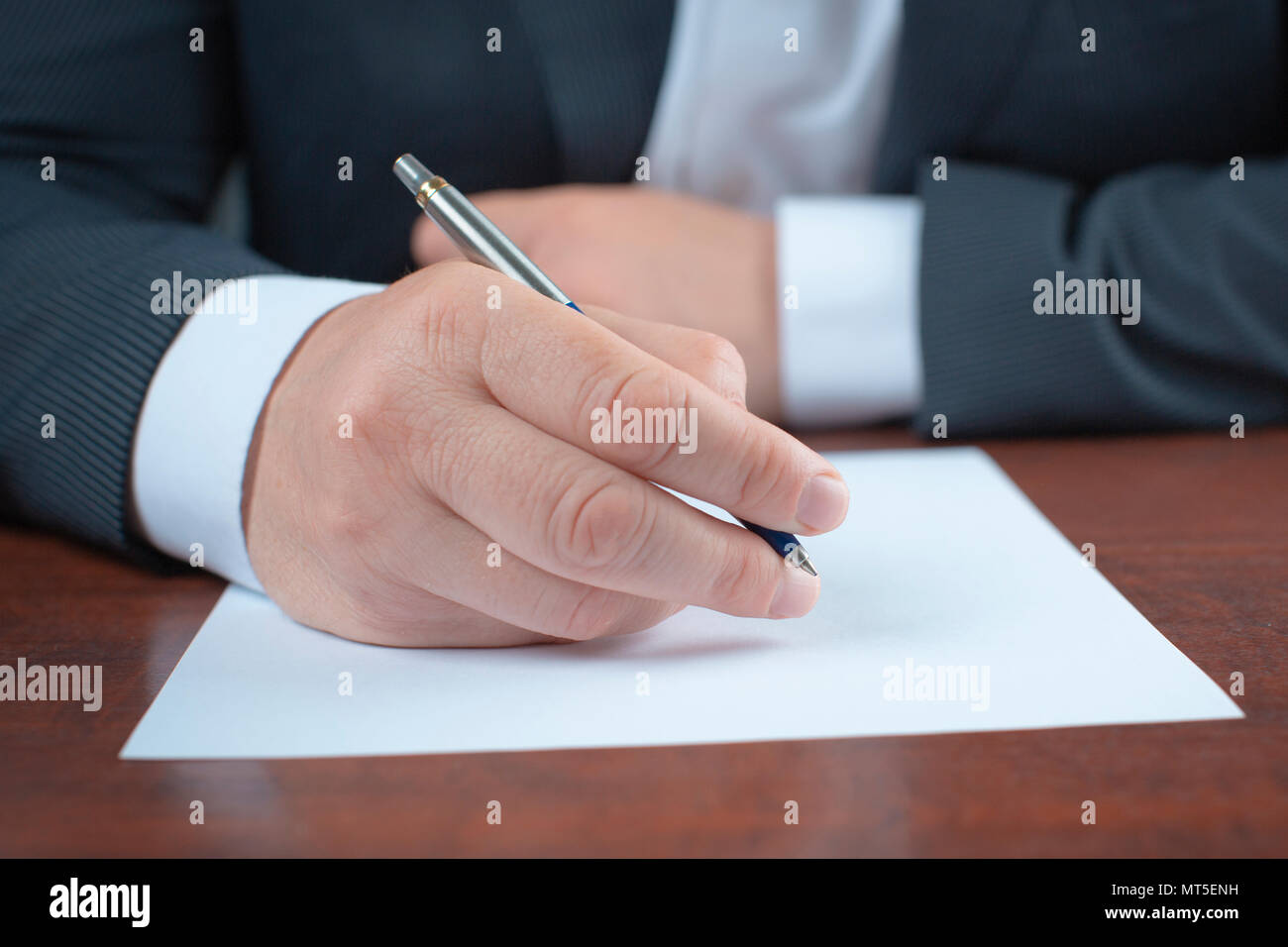 Close-up of a businessman signing an important document Horizontal ...