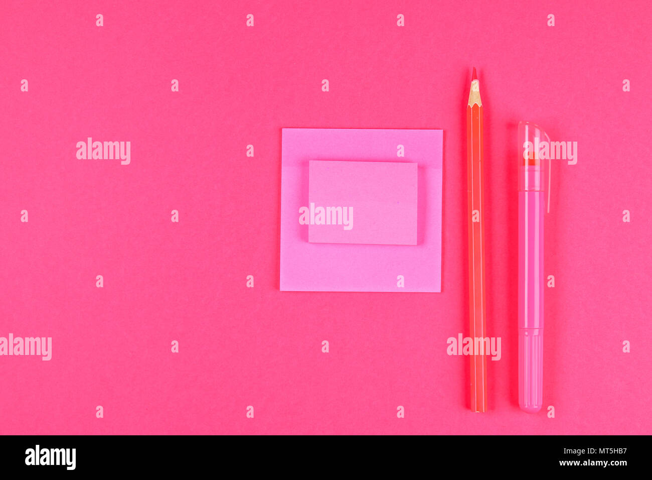 Pink felt-tip pen, pencil and sheets for notes on a pink pastel ...
