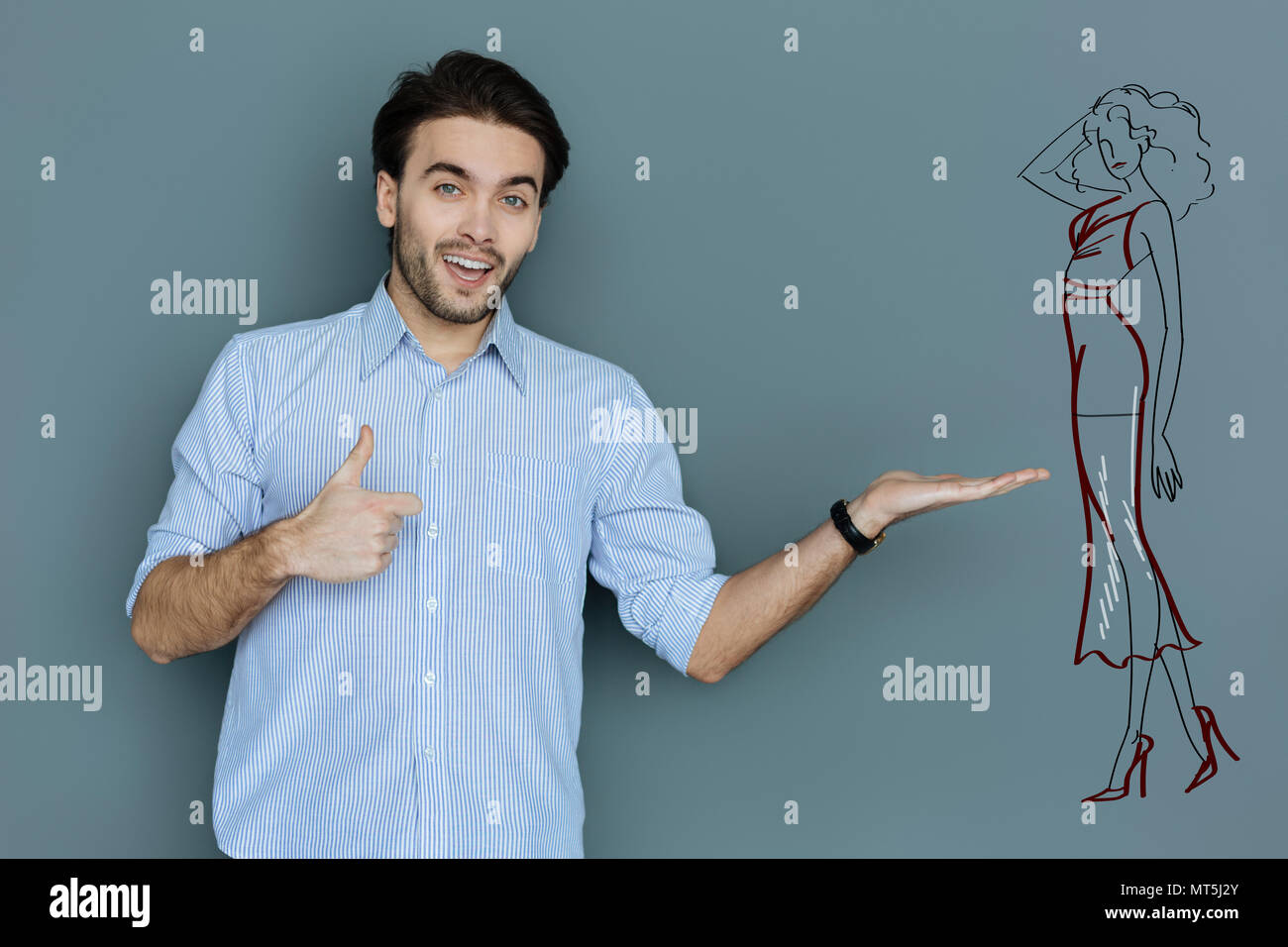 Fashion designer putting his thumb up while showing a new dress Stock ...