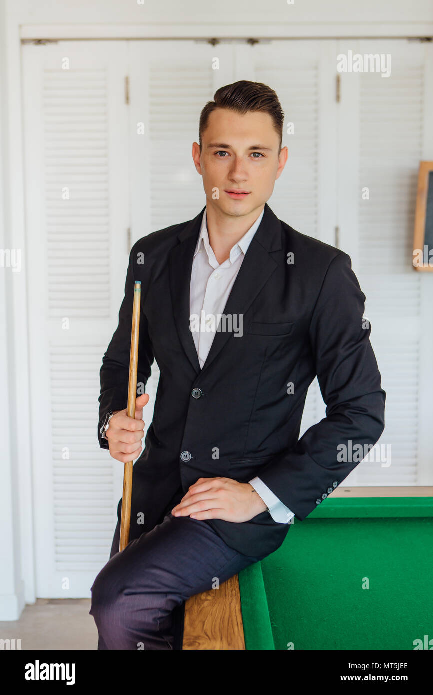 Young handsome man dressed in classic costume playing billiard game ...