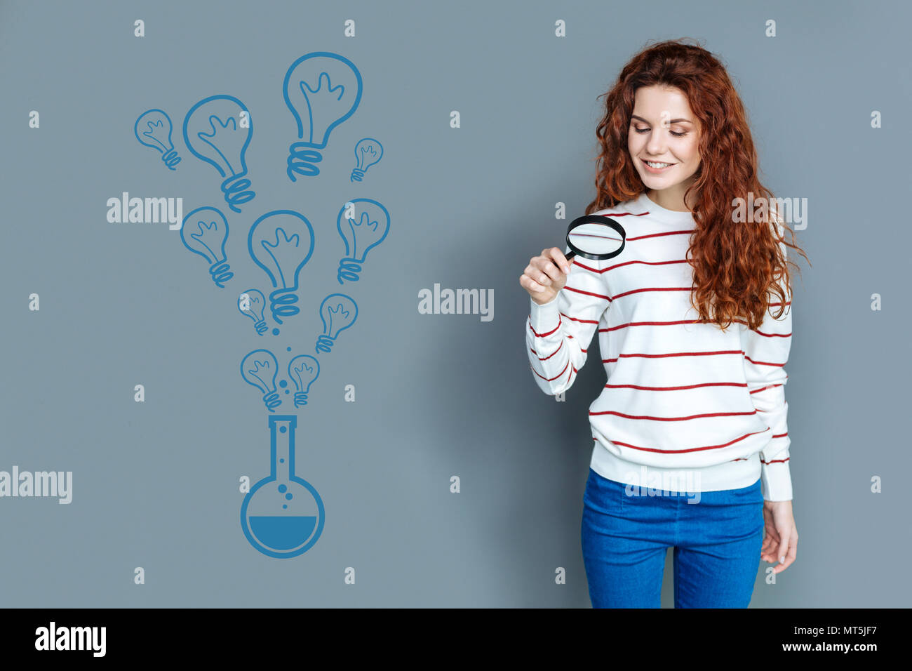 Cheerful scientist standing with a magnifying glass and smiling Stock ...