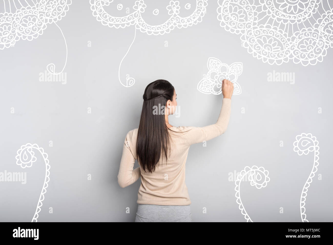 Talented painter drawing flowers on the wall and feeling good Stock ...