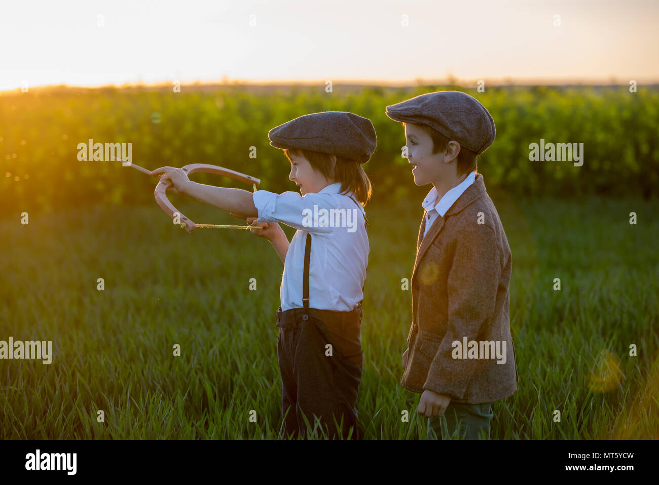 Portrait of children playing with bow and arrows, archery shoots a bow ...