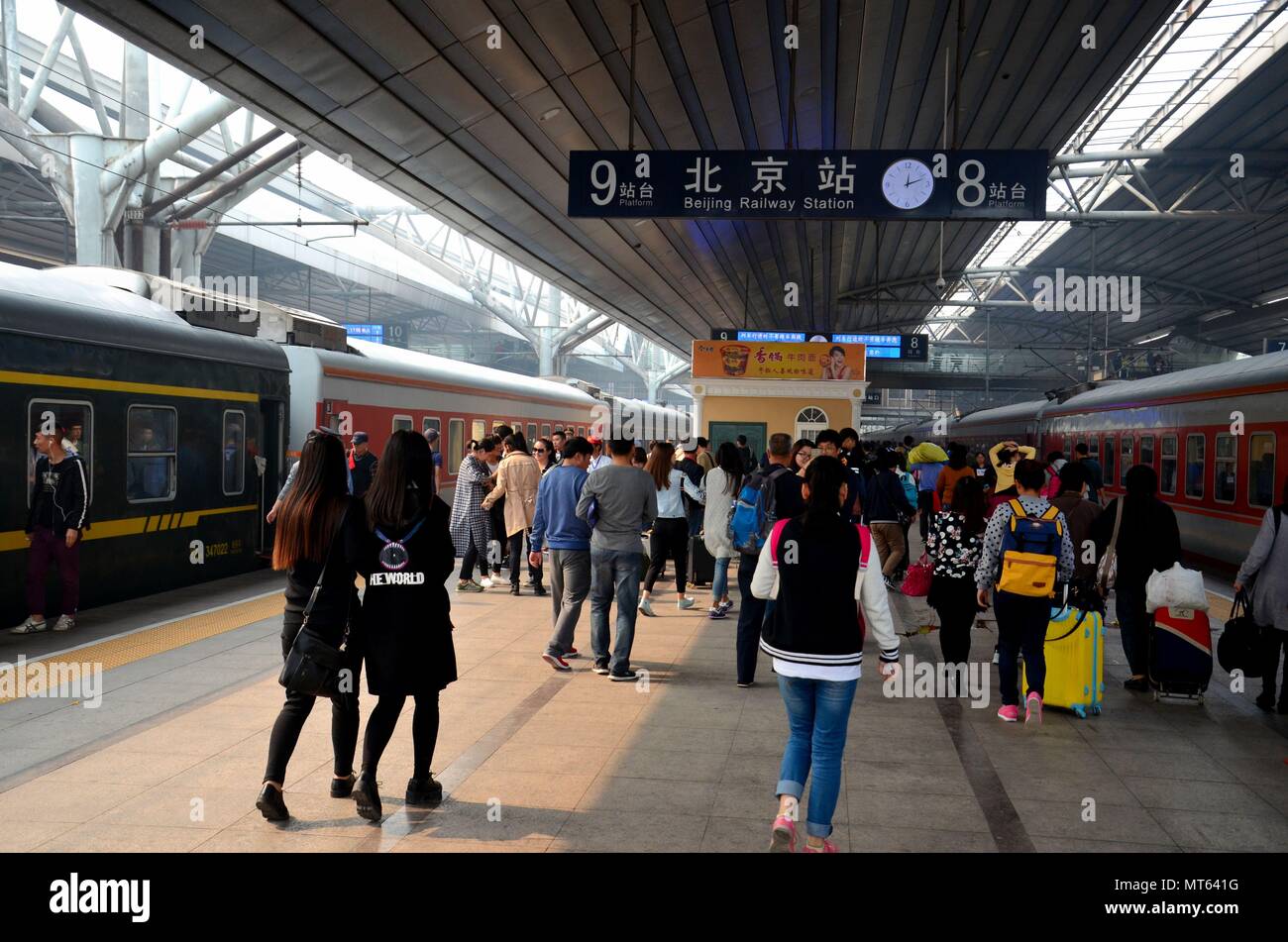 Busy platform with passengers and baggage exiting trains and greeting ...